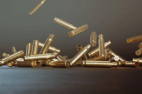 An Empty shells falling on the floor. Open fire. Gun ammunition on dark ...