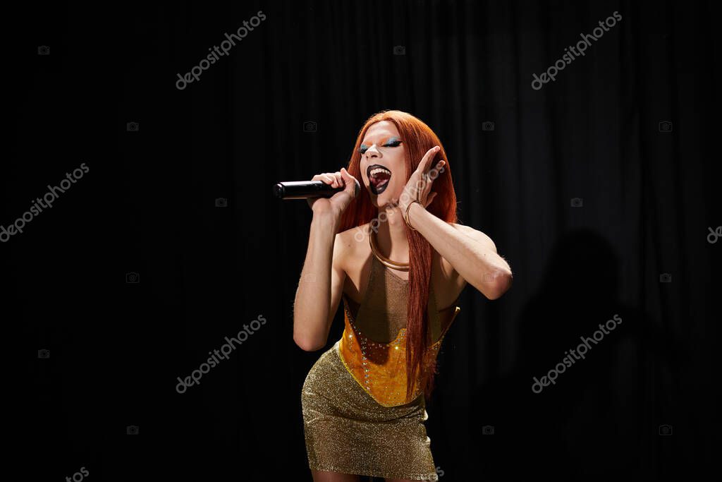 Una drag queen canta en un micrófono en el escenario. 2025