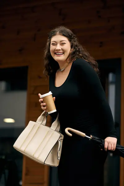 A cheerful plus size woman walks outside, holding a warm drink and ...