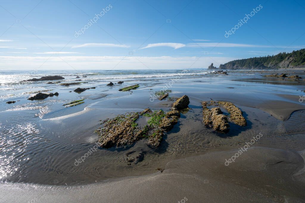 Rocas y piscinas de marea expuestas durante la marea baja en la playa ...