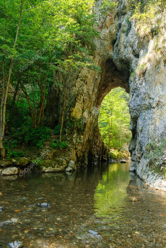 Un arroyo montañoso que fluye a través de un cañón estrechado por muros ...
