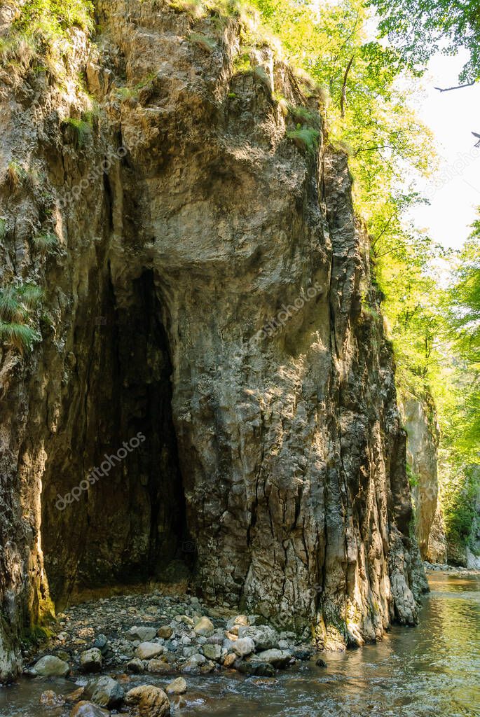 Un arroyo montañoso que fluye a través de un cañón estrechado por muros ...