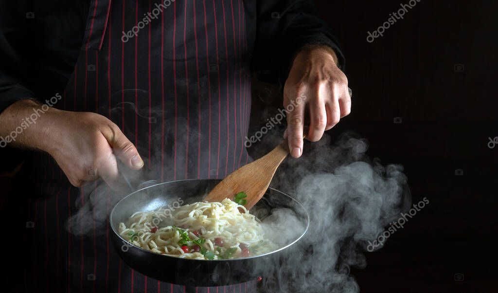 El chef prepara deliciosos espaguetis con especias y condimentos en una ...