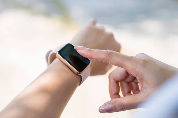 Close up shot of female's hand touching a smartwatch at outdoor in ...