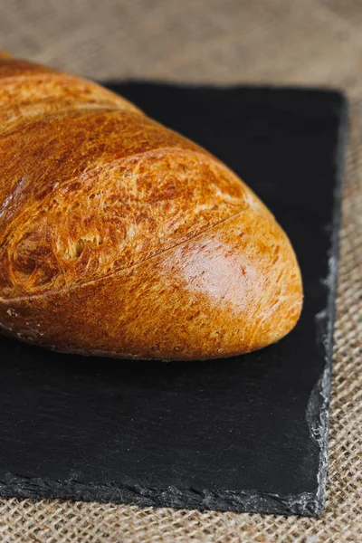 Delicious fresh rye round bread on a dark background. Crispy fresh bread. Freshly baked bread ...