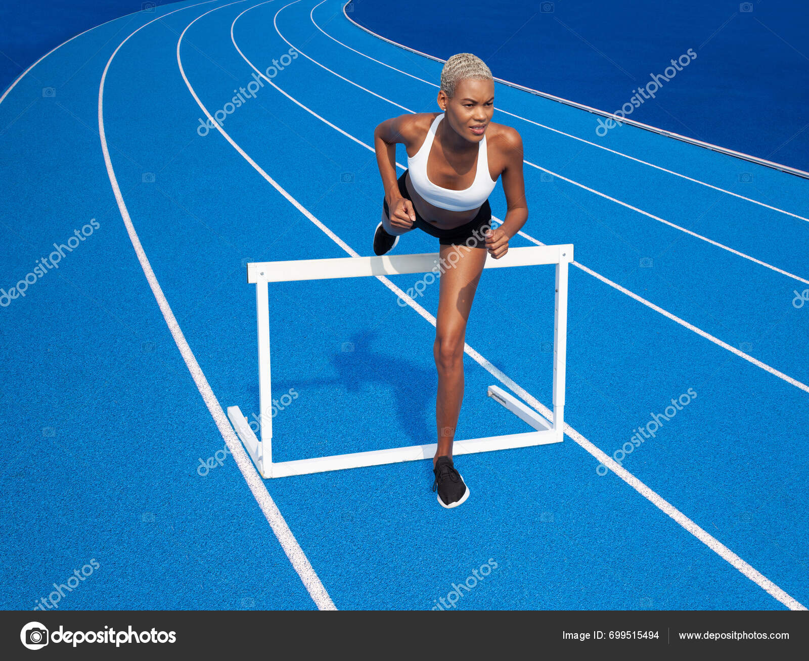 African American Female Athlete Running Olympic Track Executing Hurdle ...