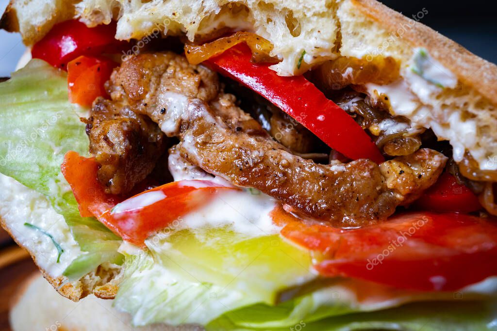 Un sándwich abundante muestra pollo a la parrilla tierno, pimientos ...