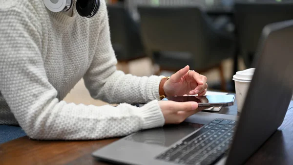 Close up view of woman using smartphone while working in the cafe with ...