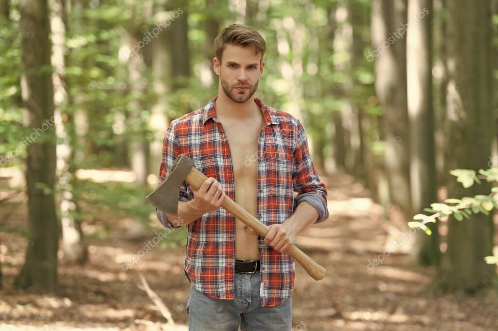 Unshaven axeman man in lumberjack style standing with axe forest ...