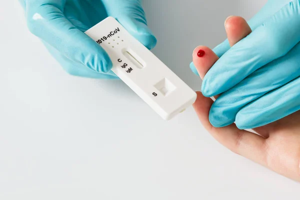 Doctor taking patient blood from finger for quick covid test. Covid ...