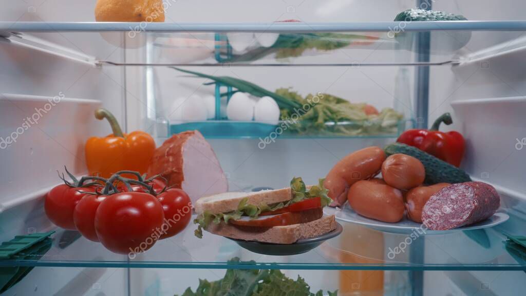Estantes del refrigerador con la comida de cerca. Una variedad de ...