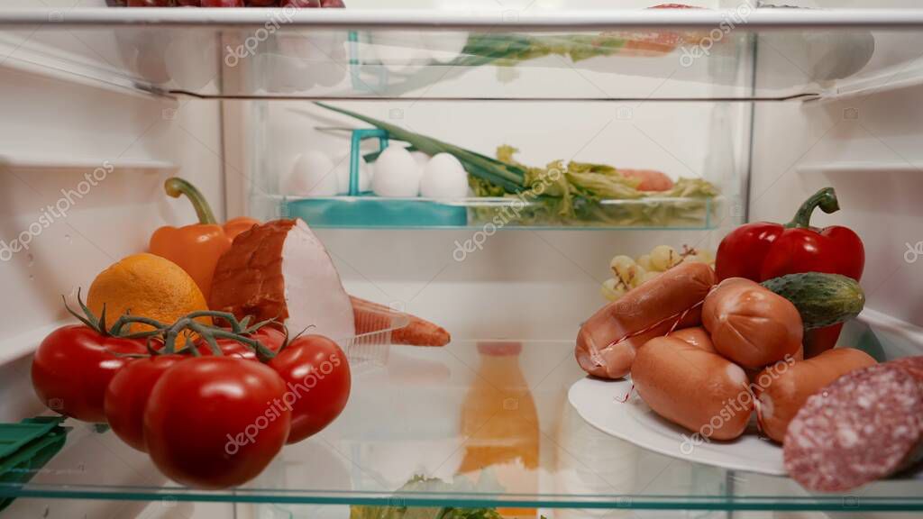 Estantes del refrigerador con la comida de cerca. Una variedad de ...