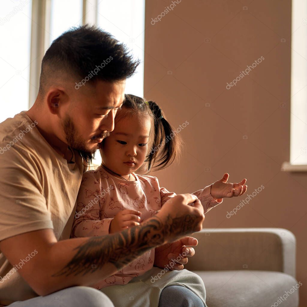 Padre e hija enfocados comprobando la temperatura del termómetro ...