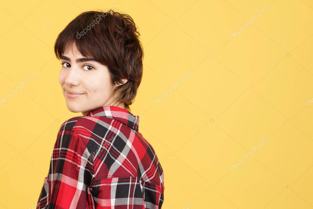 Androgynous persona girando para sonreír a la cámara en el estudio con ...