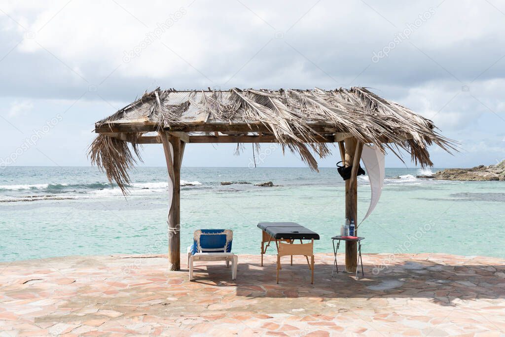 Canopy de madera con techo de hojas de palma en la playa junto al ...