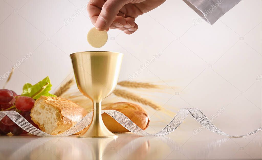 Eucaristía con la mano del sacerdote sosteniendo una hostia y una copa ...