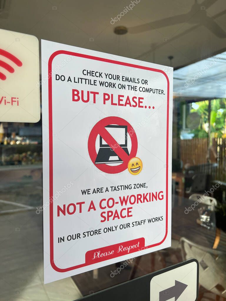 Store window sign politely indicating it's not a co-working space ...
