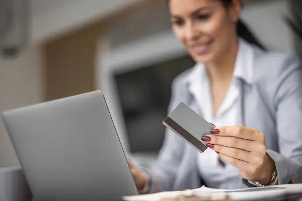 Woman typing credit card information on laptop.Young woman holding ...