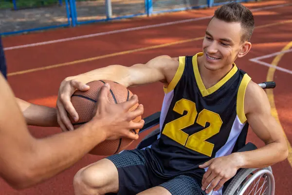 Basketball player with disability training on outdoor basketball court ...