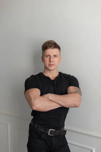 cool muscular handsome man with a hairstyle in a black mock-up T-shirt ...