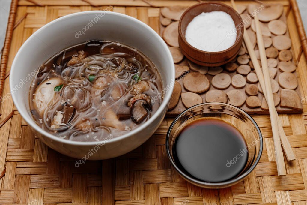 Sopa de udon con gambas y un tazón con salsa de soja en una bandeja de ...