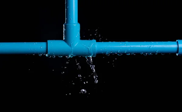 leaked and splash water from pvc plastic pipe over a black background ...