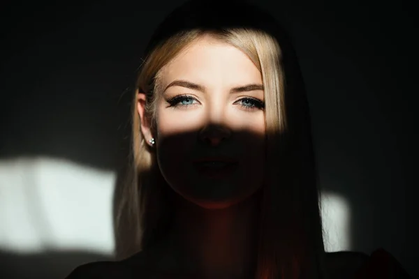 Sensual woman with shadows on beautiful face. Creative portraits with shadow and light over ...