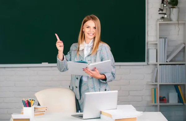 Female student with pointing finger on lesson lecture in classroom at ...