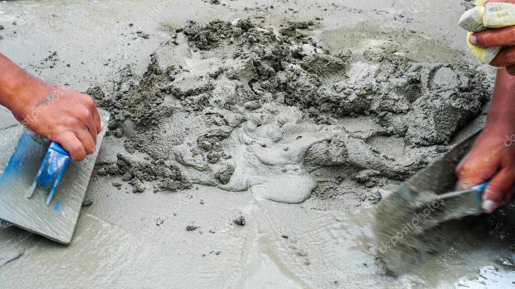 Constructor de mano con paleta nivelación de hormigón. Aplique el ...