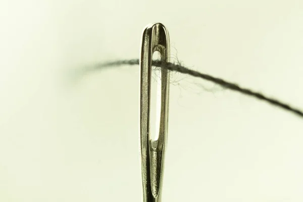 The eye of a needle with a thread close-up. Sewing needle with ...