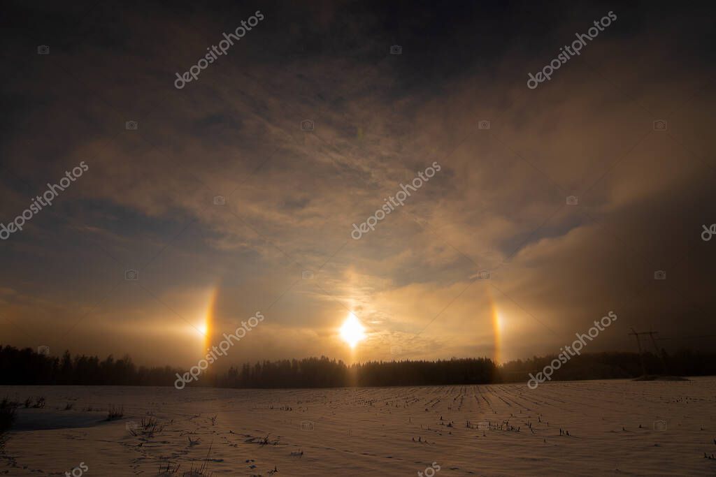 Puesta de sol en invierno y fenómeno atmosférico natural Halo, parhelio ...
