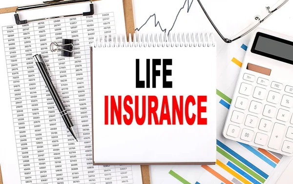 LIFE INSURANCE text on a notebook with chart, calculator and pen 2024