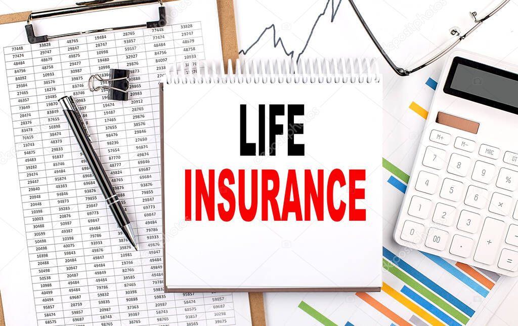 LIFE INSURANCE text on a notebook with chart, calculator and pen 2024