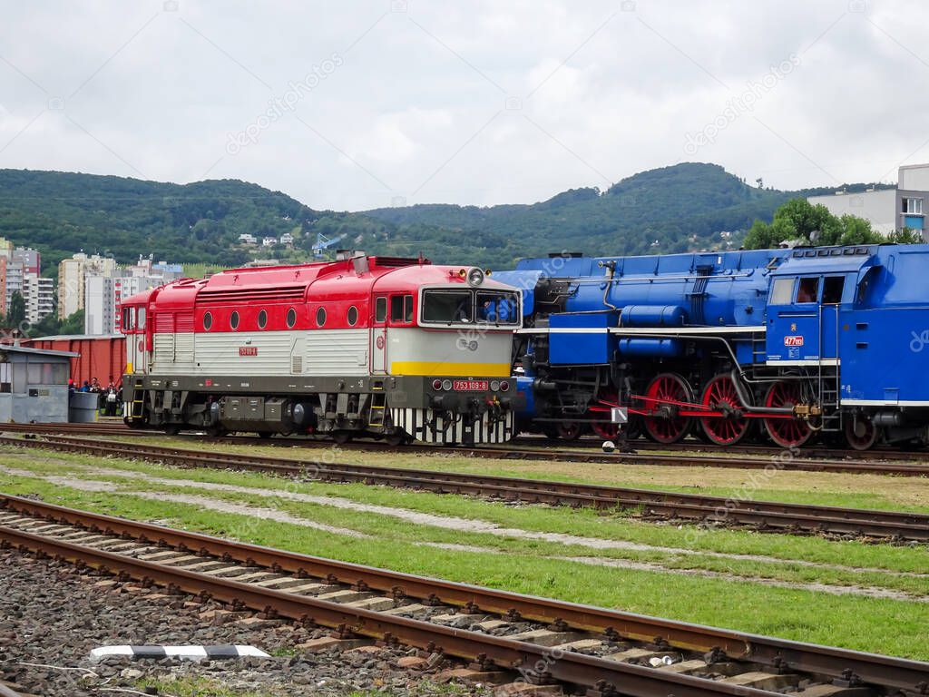 An old diesel locomotive stands on the tracks at the train station. 2024