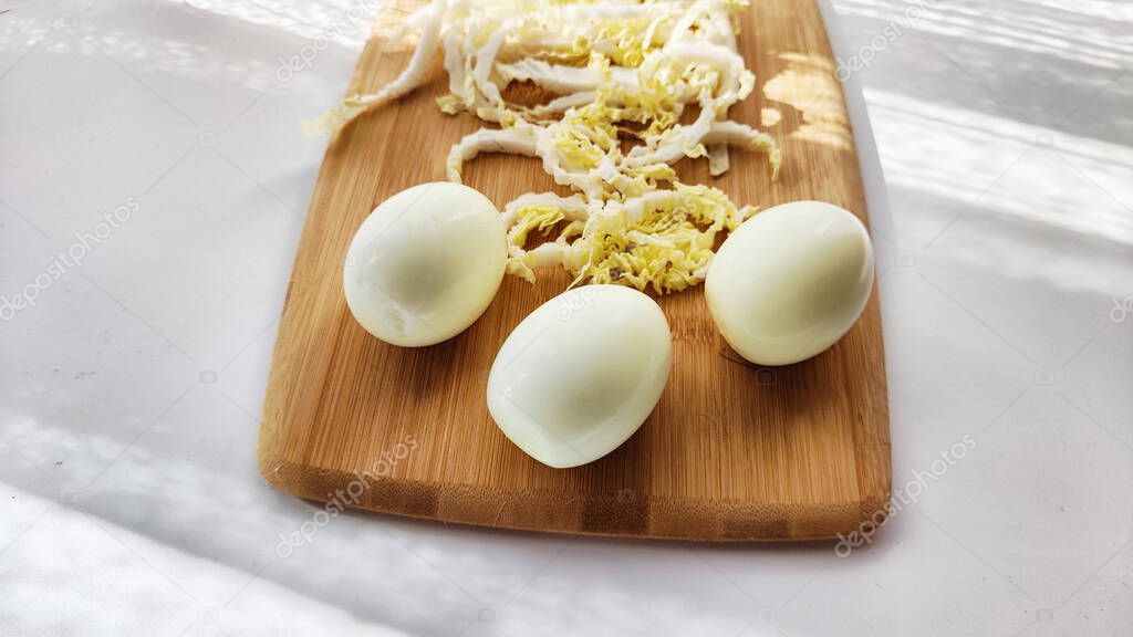 Repollo de Pekín picado y huevos pelados en la tabla de cortar como ...