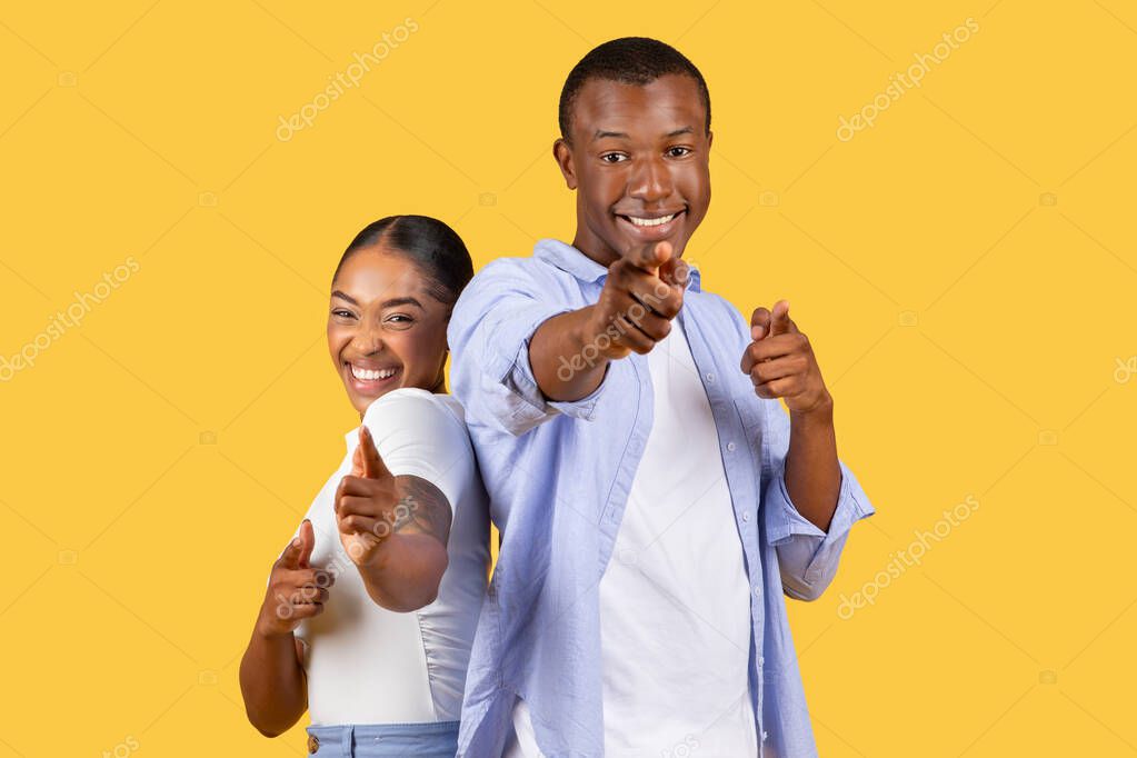 Exuberant black couple joyfully pointing at the viewer, with radiant ...