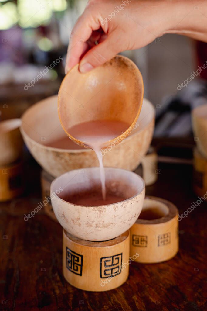 Mano vertiendo en un tazón la bebida tradicional de los pueblos ...