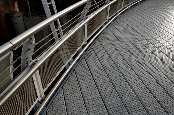 staircase and wide pedestrian bridge with perforated metal floor ...