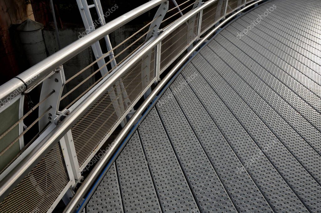 staircase and wide pedestrian bridge with perforated metal floor ...
