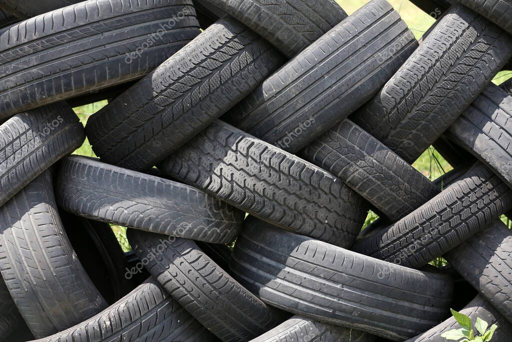 Neumáticos viejos en fila como una valla en un patio rural. Los ...