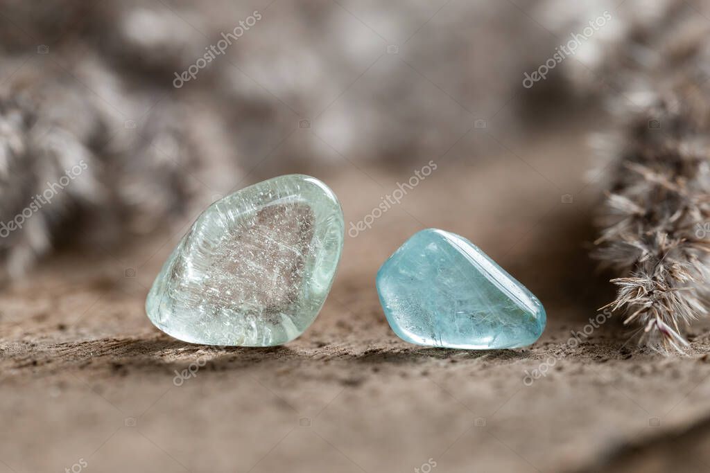 Dos muestras de piedras minerales de topacio azul pálido sobre madera ...