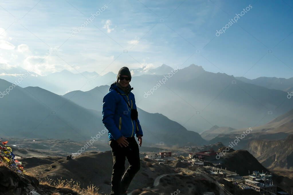 Un hombre en traje de senderismo de pie en la cima de una montaña con ...