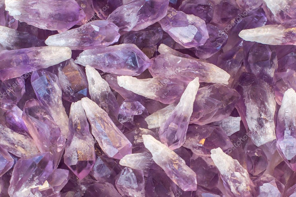 A stack of amethyst crystals with vitreous luster and prismatic tips. A ...