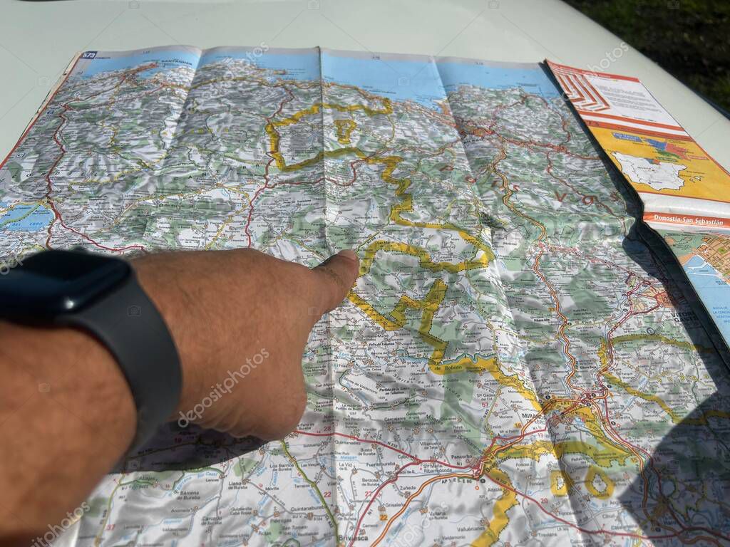 Mans mano con smartwatch, apuntando a un mapa del País Vasco con un ...