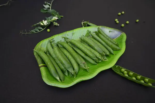 Fresh Green peas on black background. There is a lot of vitamins and ...