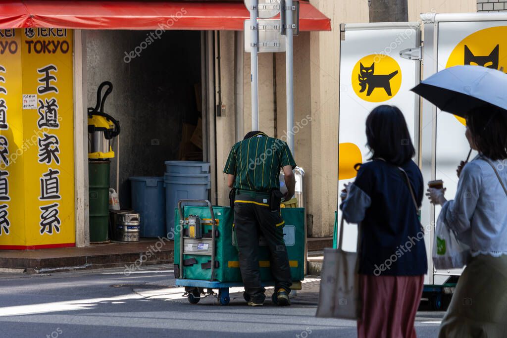Tokio, Japón, 26 de octubre de 2023: Trabajadores y peatones en una animada calle del distrito ...