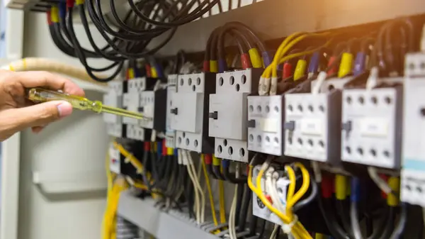 Electricians hands testing current electric in control panel. - Stock ...