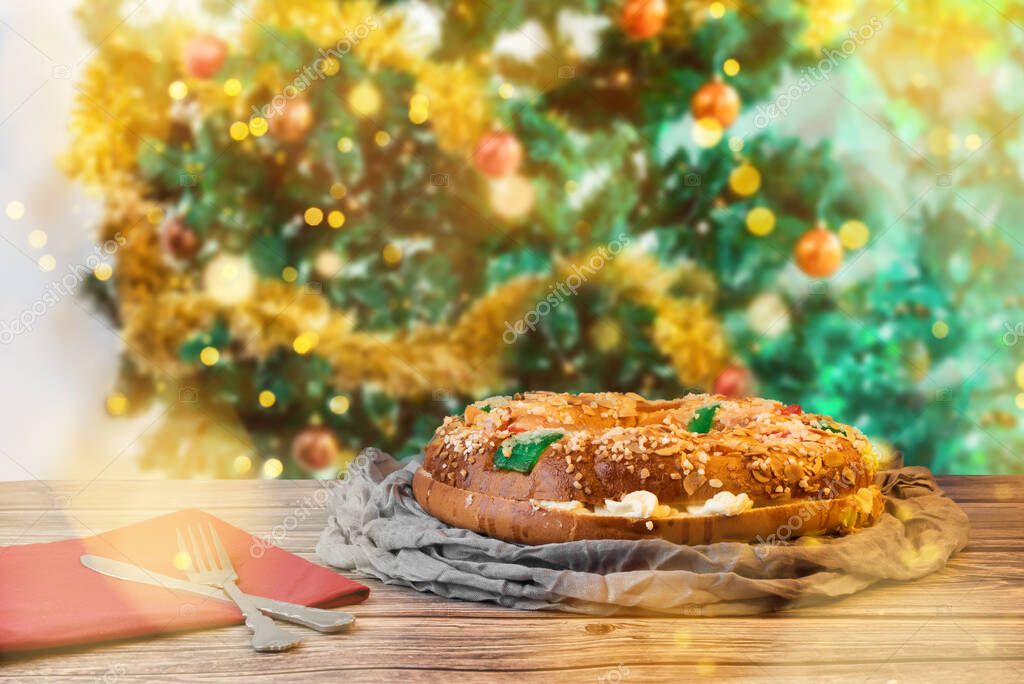 Pastel de Epifanía relleno de crema "Roscon de Reyes" junto a un árbol ...