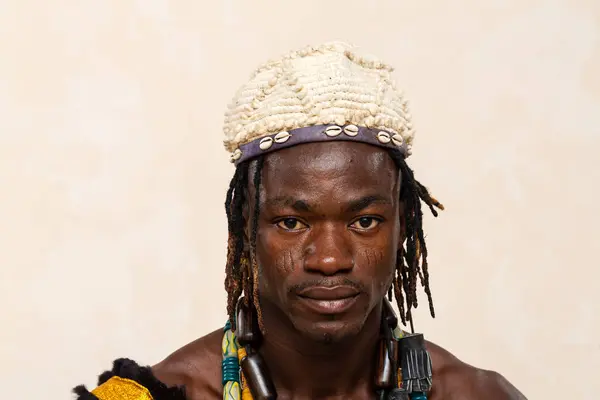 Close-up portrait of an African man showcasing traditional adornments ...