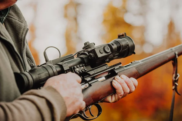 Portrait of hunter or ranger with gun or rifle in the forest looking ...